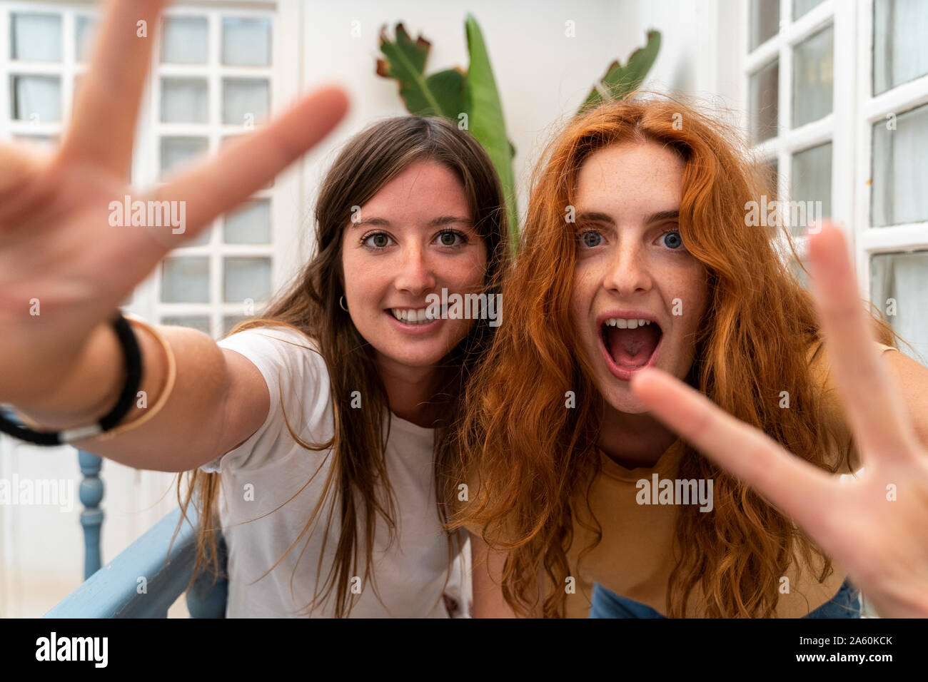 Portrait of two friends showing victory signs Stock Photo - Alamy
