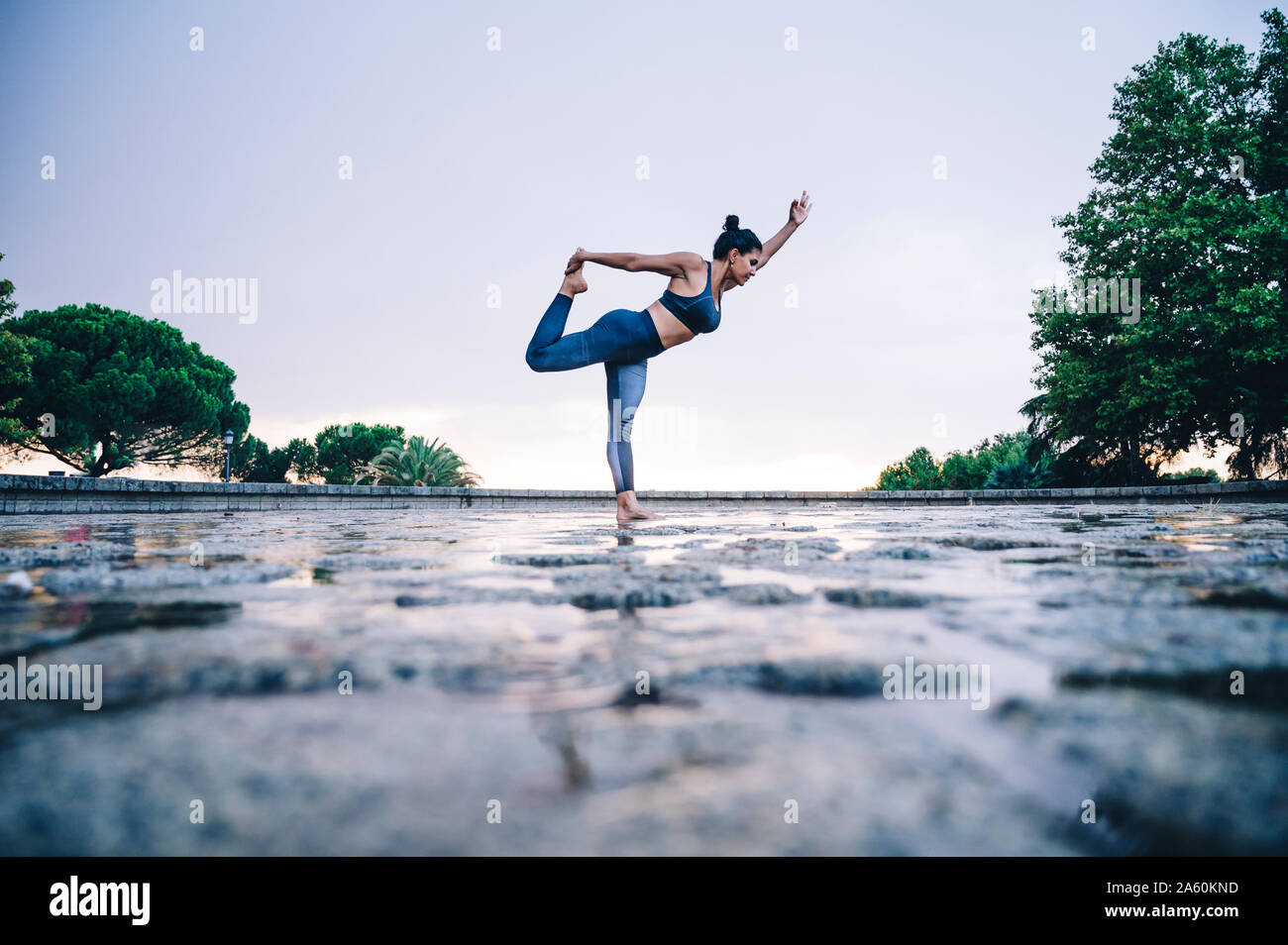 Woman practicing yoga in the rain, dancer position Stock Photo - Alamy