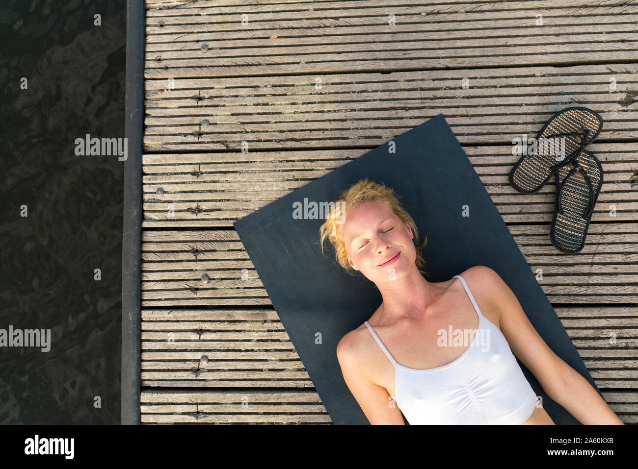 Top view of young woman lying on a jetty Stock Photo - Alamy