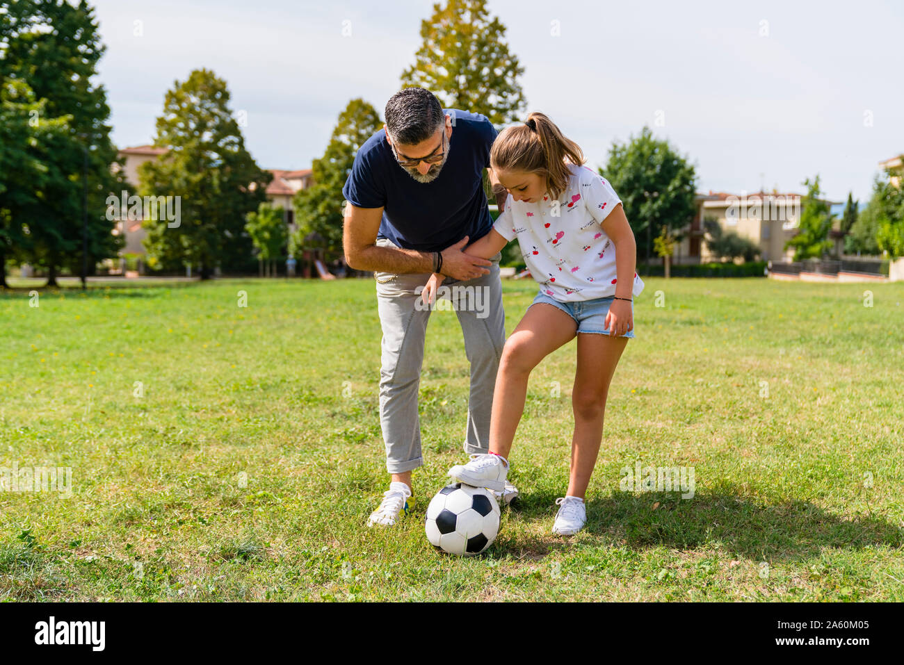 Father and daughter playing football on a meadow Stock Photo - Alamy