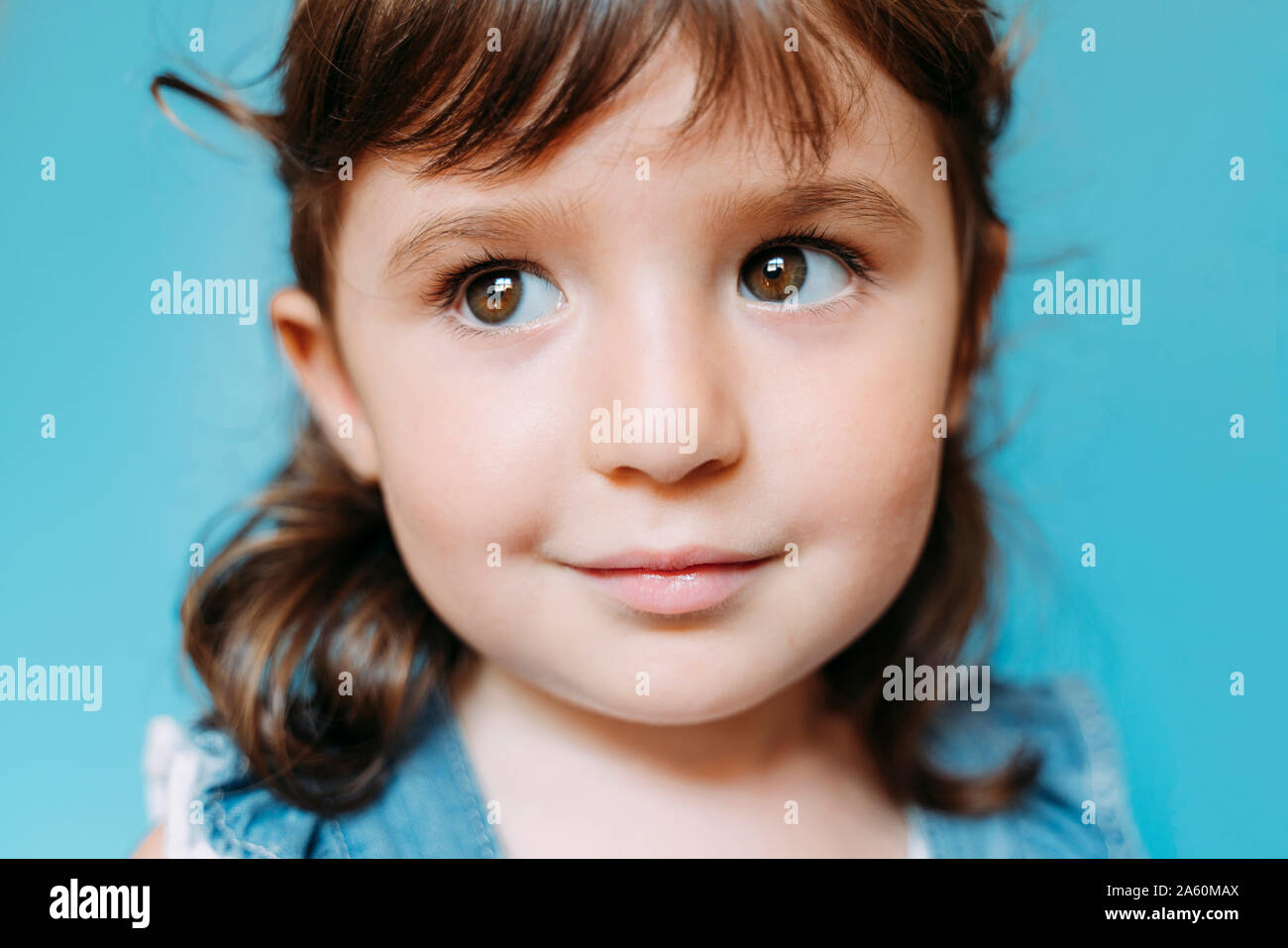 Portrait of cute little girl, blue background Stock Photo - Alamy