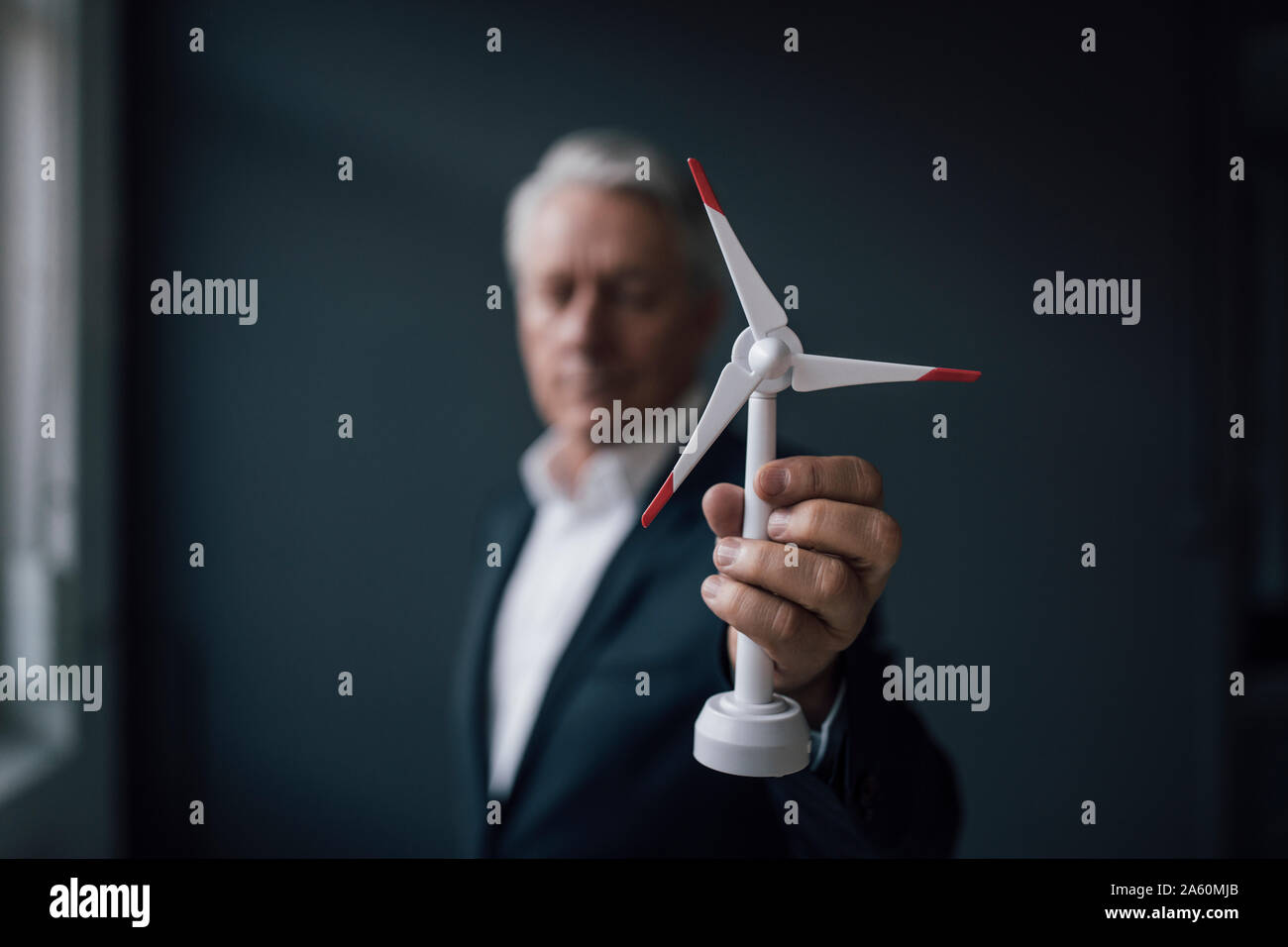 Senior businessman holding wind turbine model Stock Photo - Alamy
