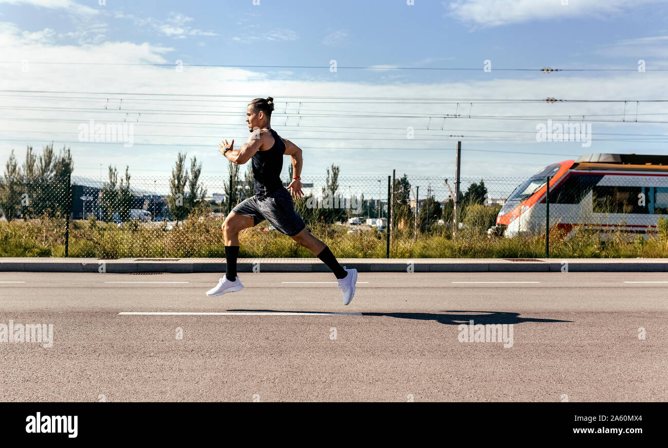Sporty young man running on a road Stock Photo - Alamy