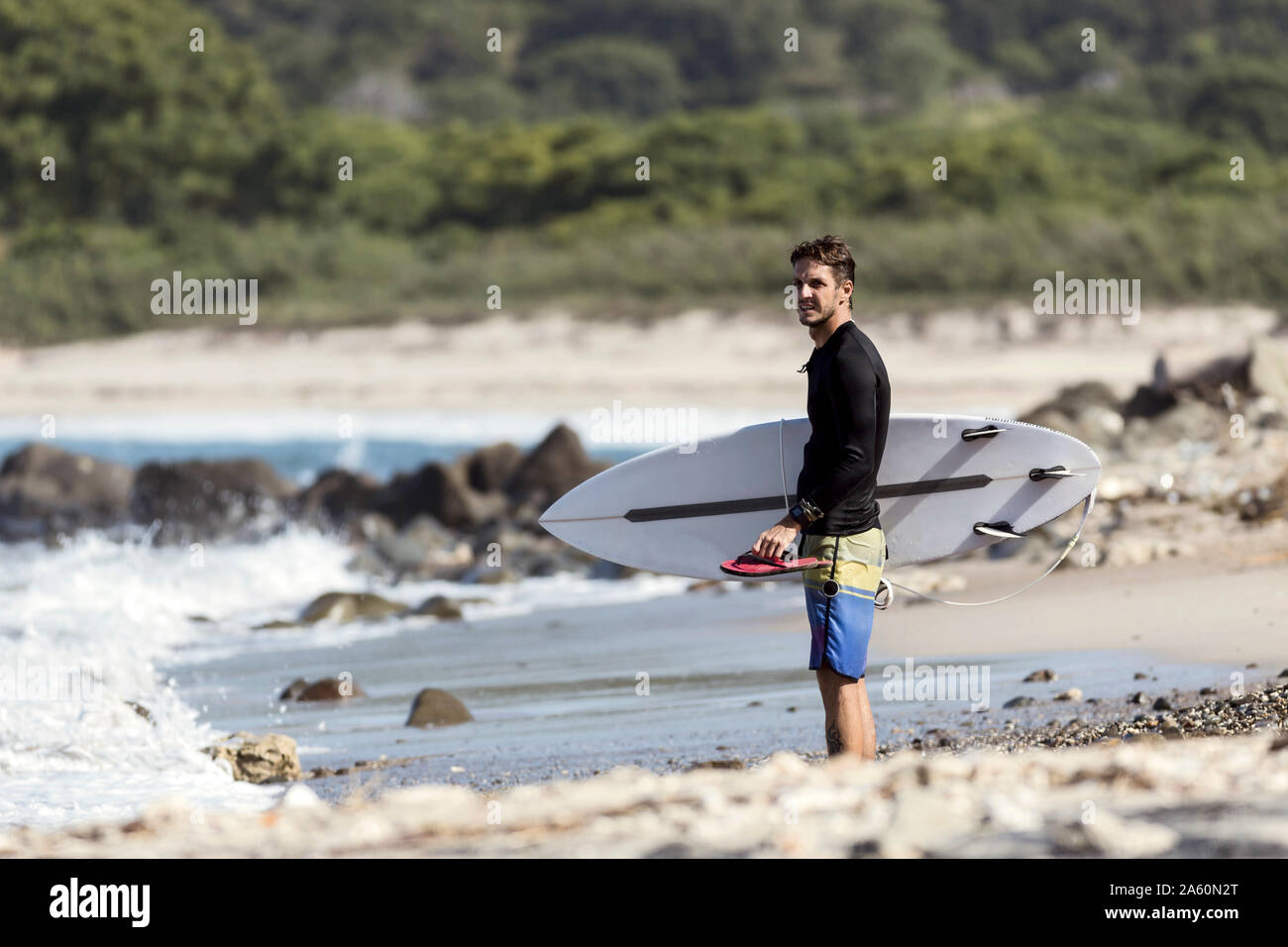 Surfer standing at the beach Stock Photo - Alamy