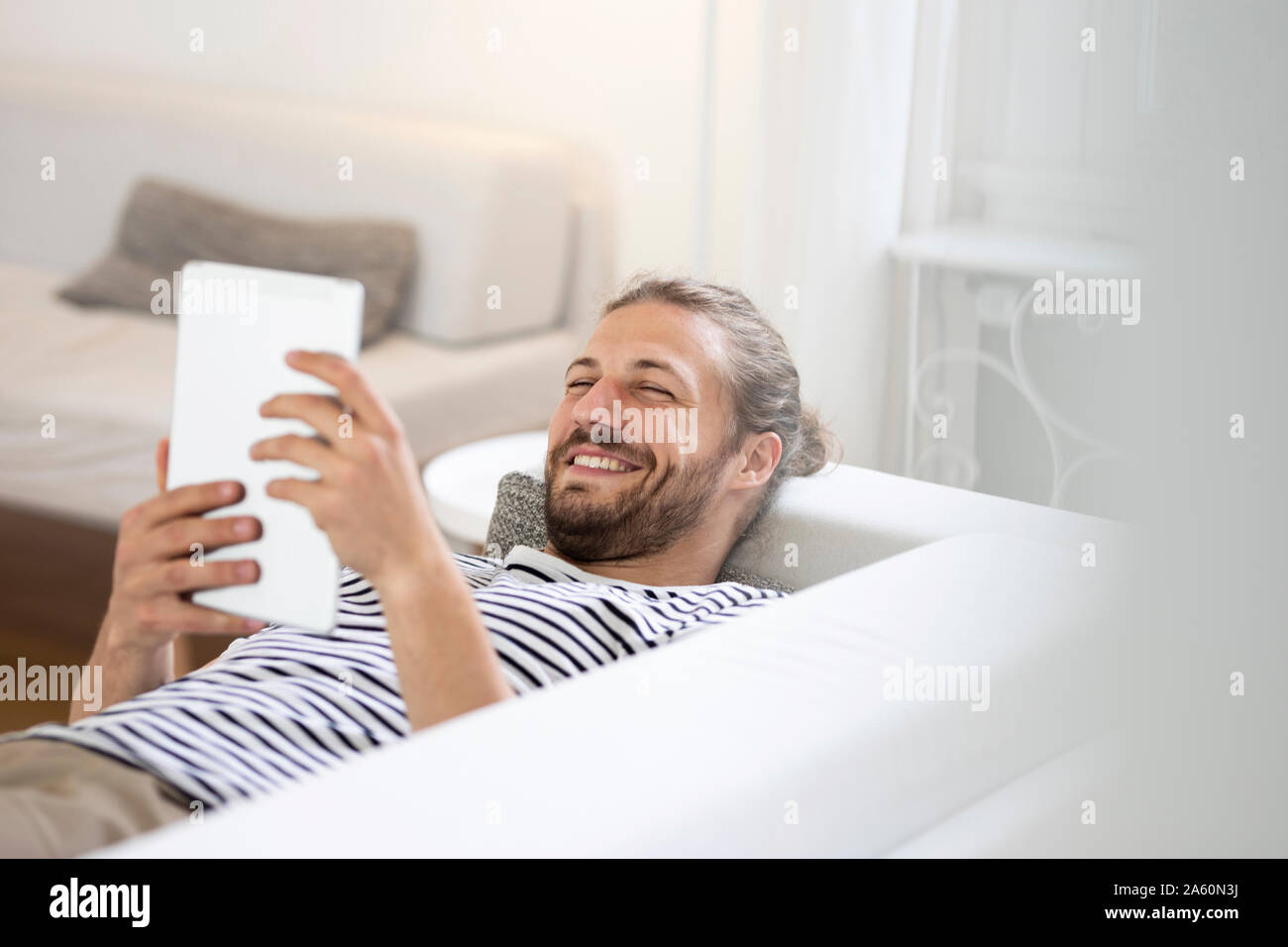 Smiling man lying on couch hi-res stock photography and images - Alamy