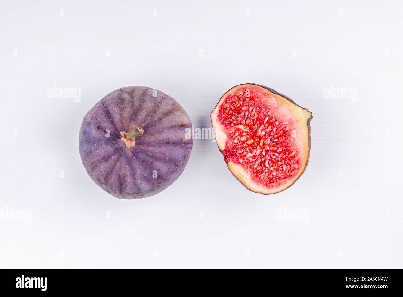 Purple fresh whole and sliced half figs on white background Stock Photo ...