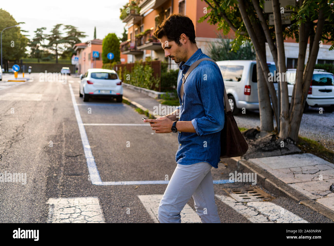 Man crossing street in the city Stock Photo - Alamy