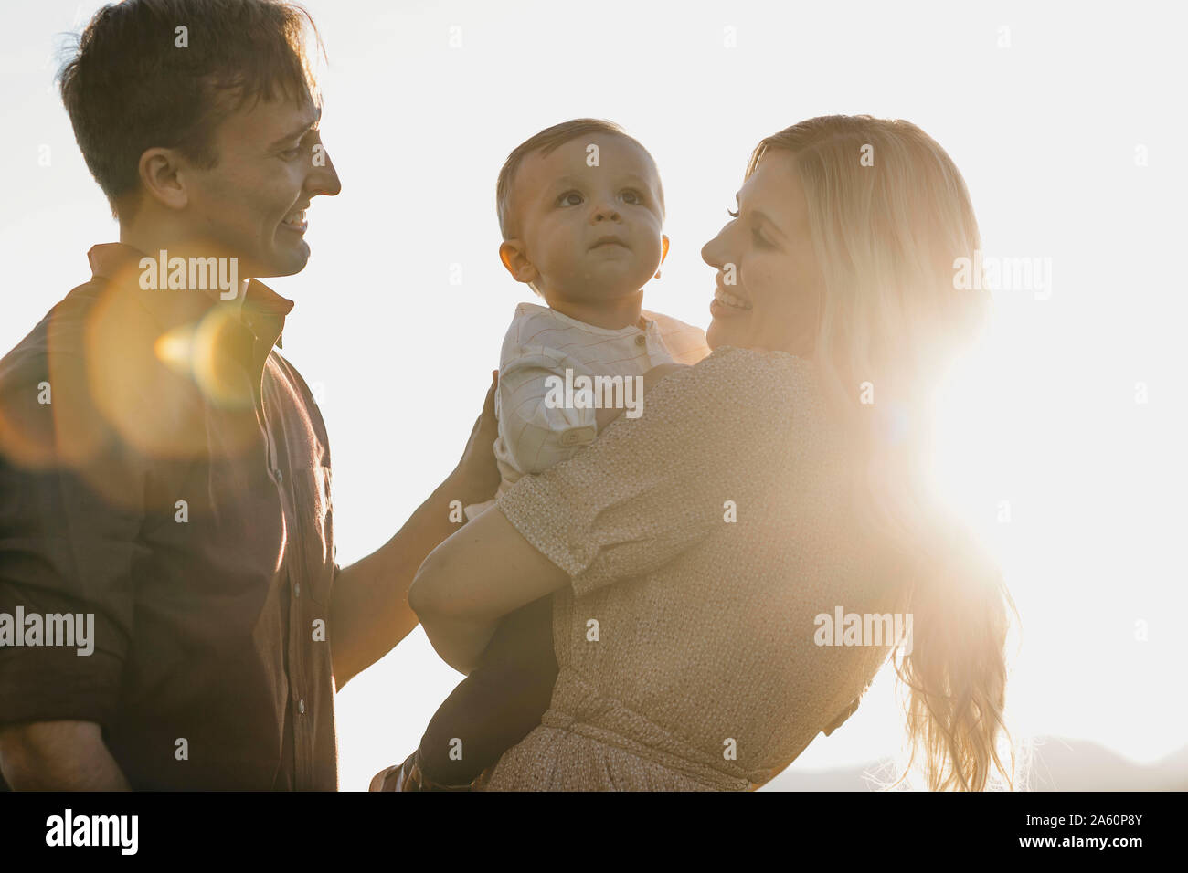 Happy family with little son in sunlight Stock Photo - Alamy