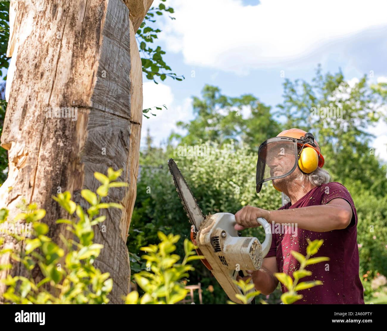 Wood carver carving sculpture, using chainsaw Stock Photo - Alamy
