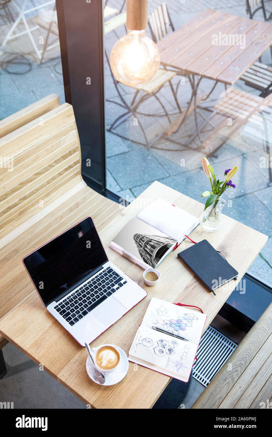 Laptop and books on table in a cafe Stock Photo - Alamy