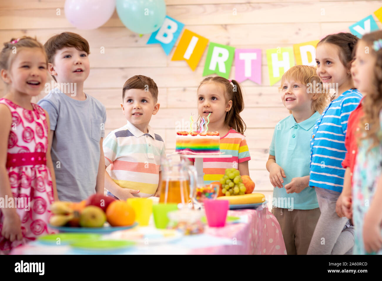 Group of adorable kids having fun by festive table at birthday party ...