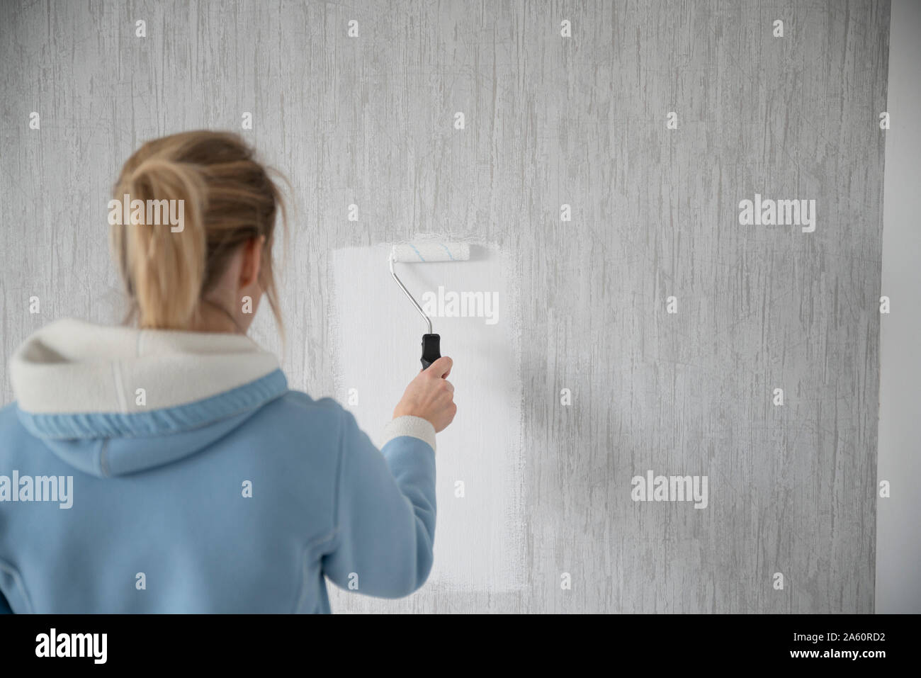 Back view of woman painting wall Stock Photo - Alamy