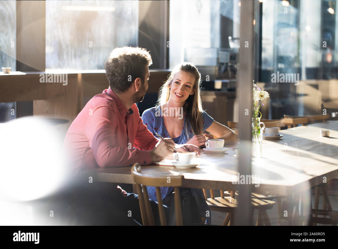 Woman and man talking at table in a cafe Stock Photo - Alamy