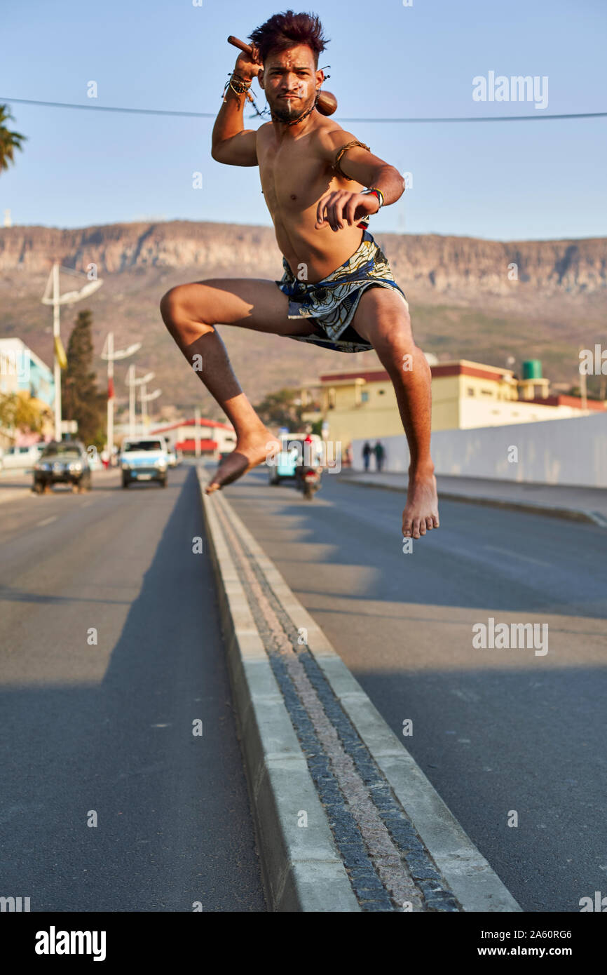 Tribal man with his traditional arch and arrows jumping on a median ...