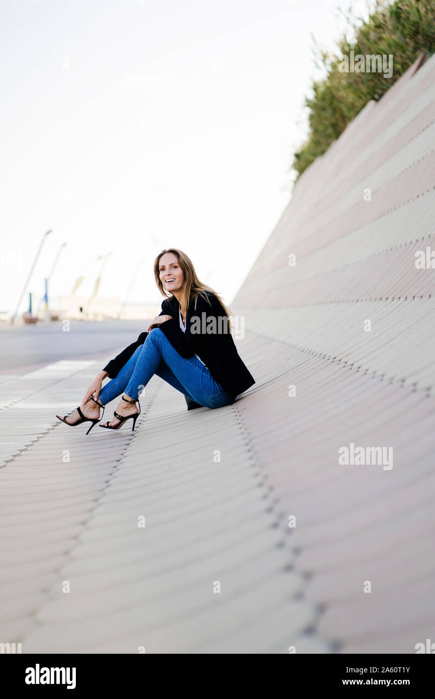 Businesswoman relaxing outdoors sitting on slabs Stock Photo - Alamy