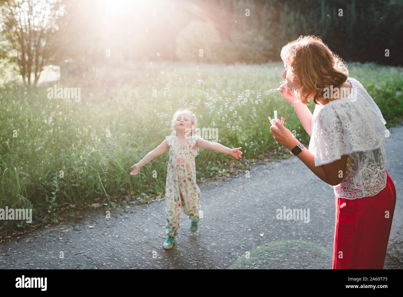 Mother making soap bubbles for her little daughter Stock Photo - Alamy