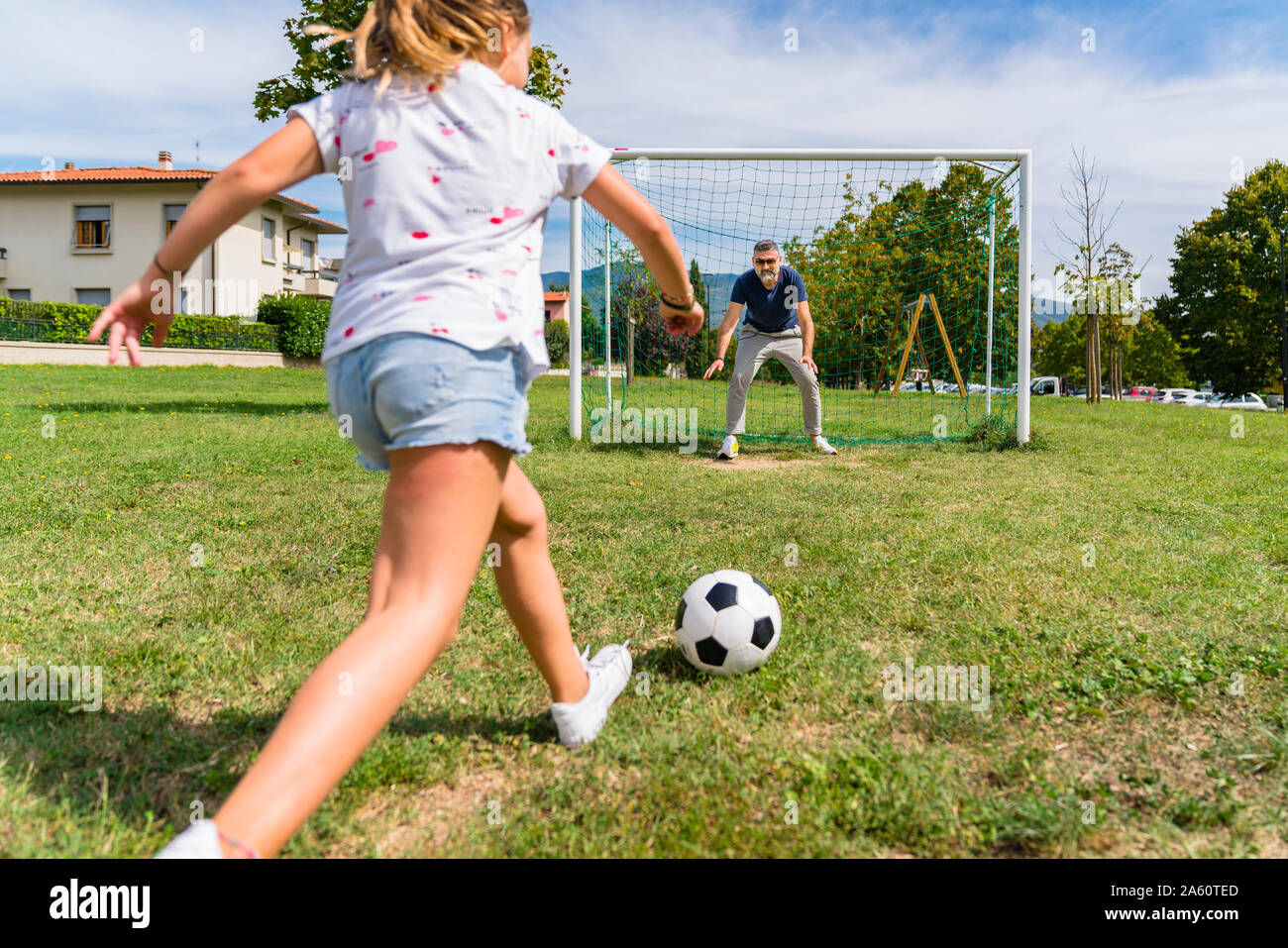 Father and daughter playing football on a meadow Stock Photo - Alamy