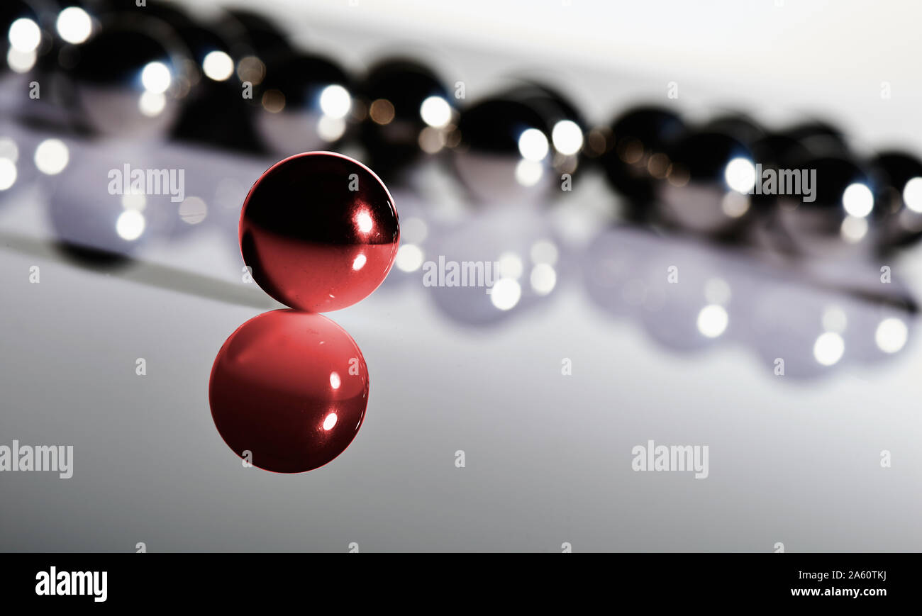 One Red metal Ball Stand Out From The Crowd on white Stock Photo - Alamy