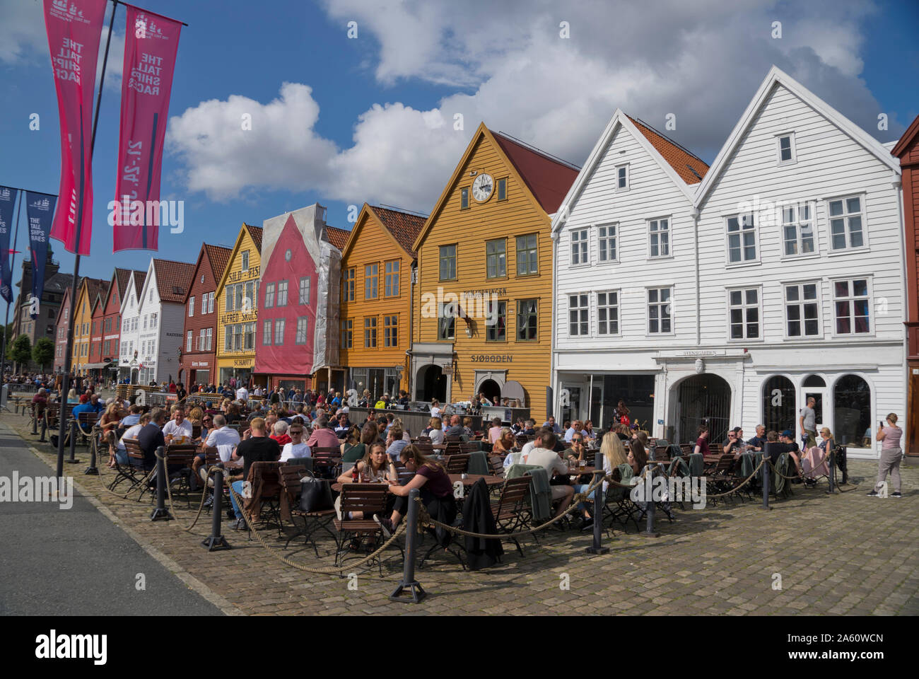 Tourists sit in the sun in outdoor bars and cafes in the old wharf and ...