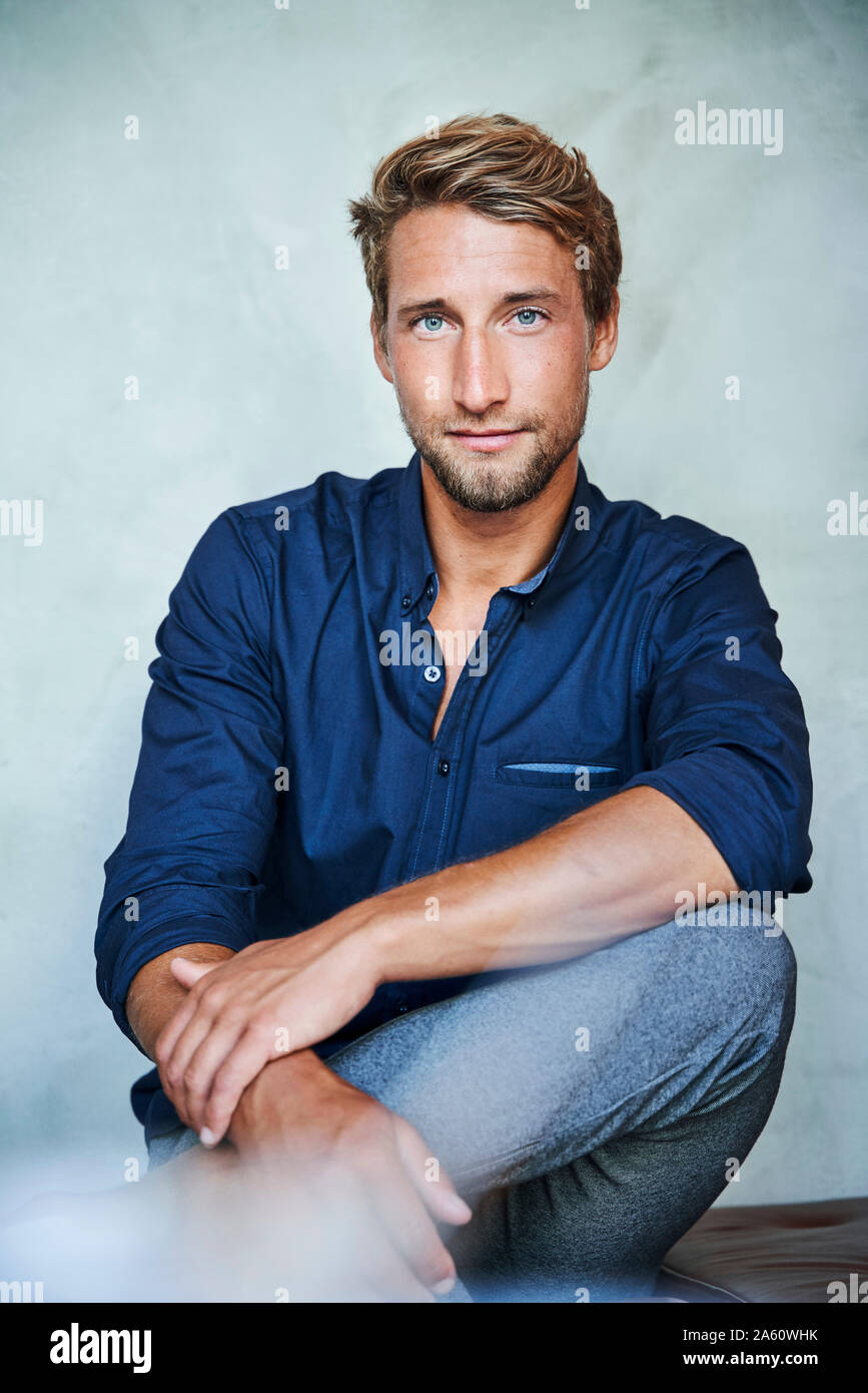 Portrait of confident young man sitting down Stock Photo - Alamy