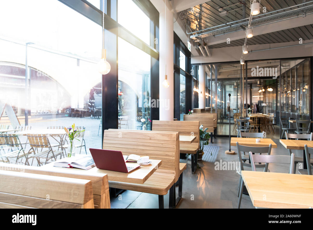Laptop and books on table in a modern cafe Stock Photo - Alamy