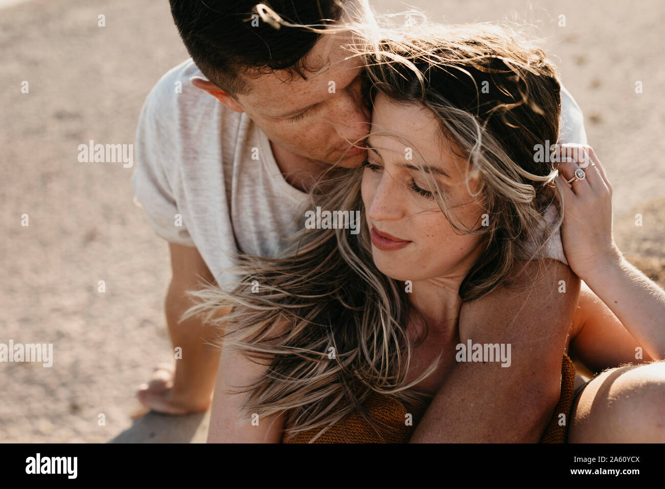Affectionate young couple on the beach Stock Photo - Alamy