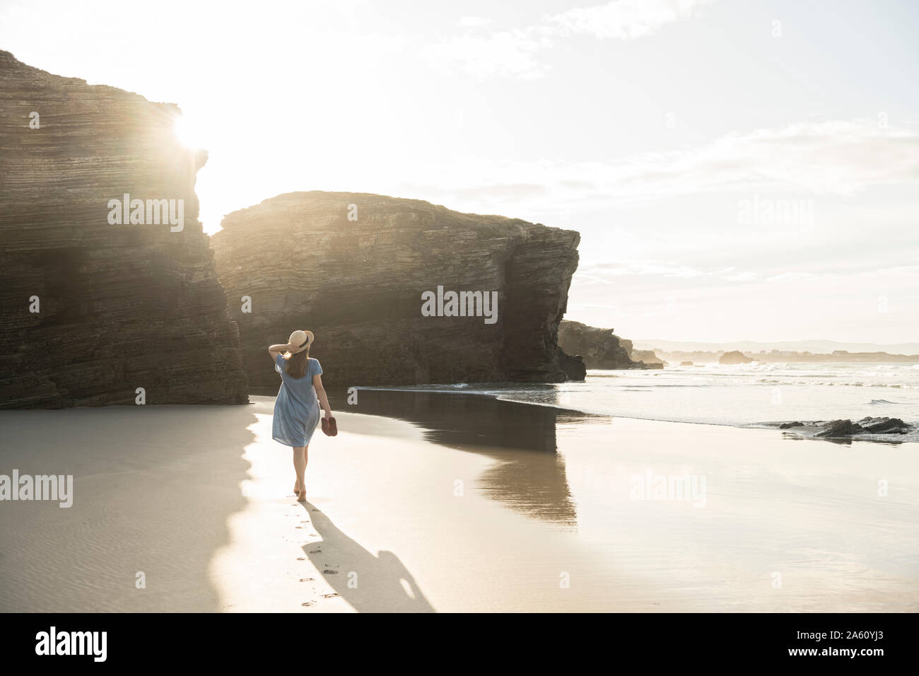 Woman walking on beach with rocks hi-res stock photography and images ...