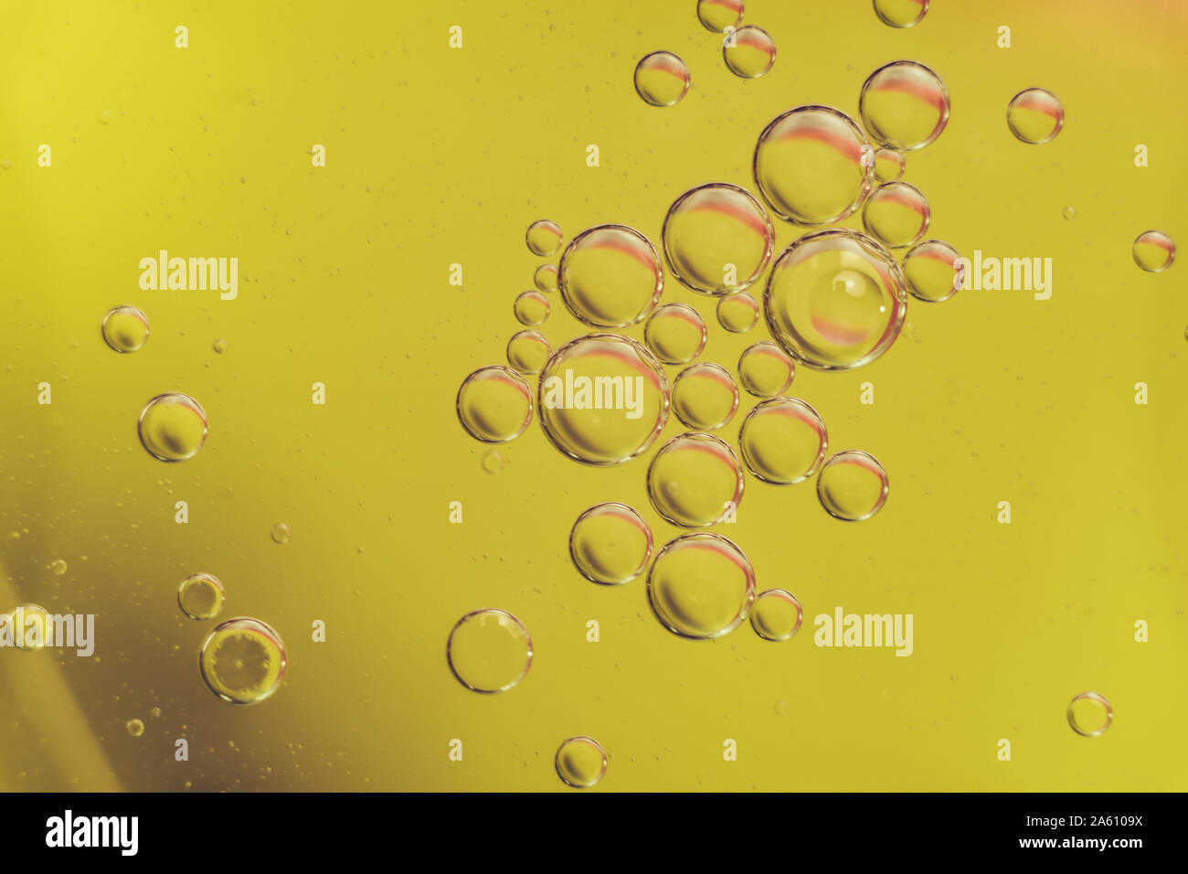 Beautiful mixing water and oil on a yellow background Stock Photo - Alamy