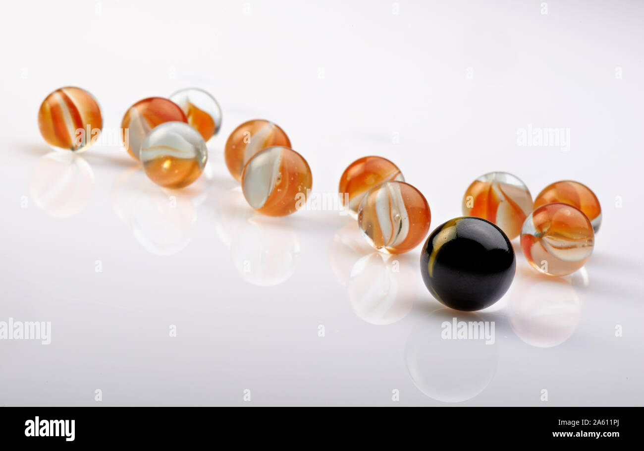One Black Marbles Ball Stand Out From The Crowd on white Stock Photo ...