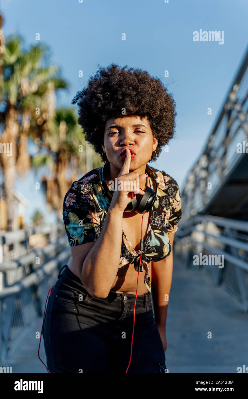 Female Afro-American with headphones, finger on lips Stock Photo - Alamy