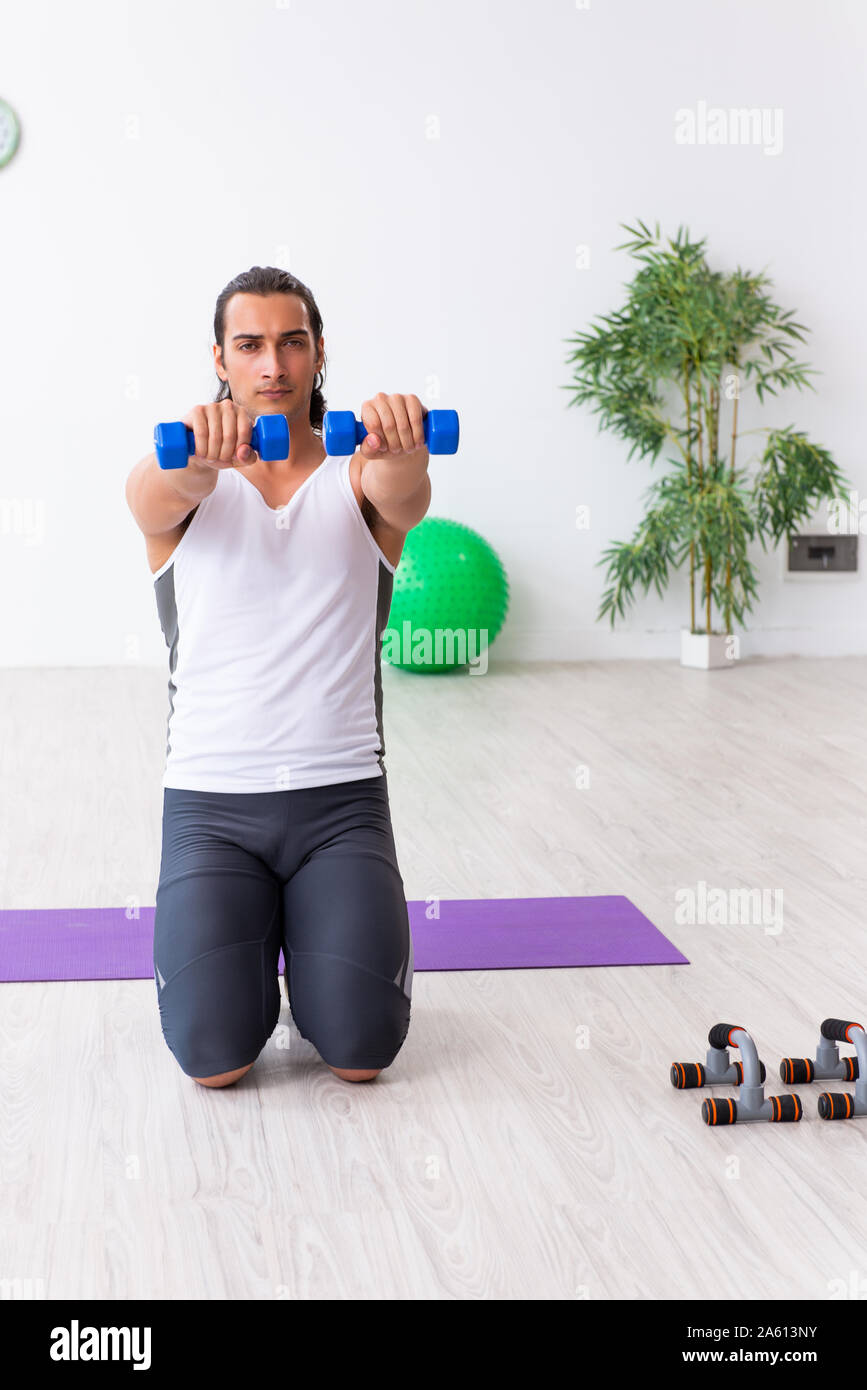 The young handsome man doing sport exercises indoors Stock Photo - Alamy