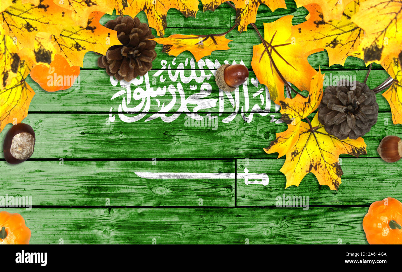 Saudi Arabia flag on autumn wooden background with leaves and good ...