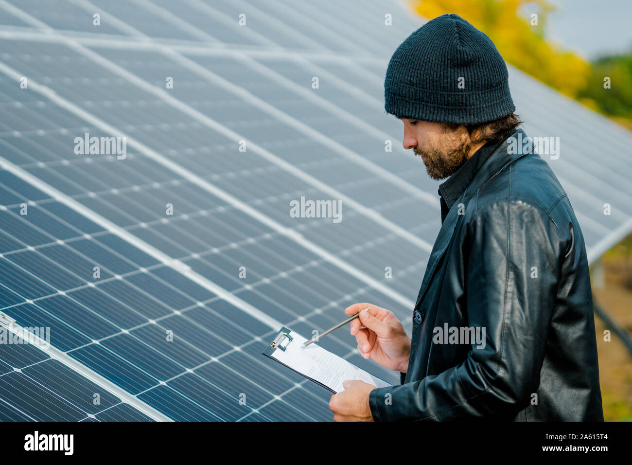 Man write notes on clipboard beside solar battery Stock Photo - Alamy