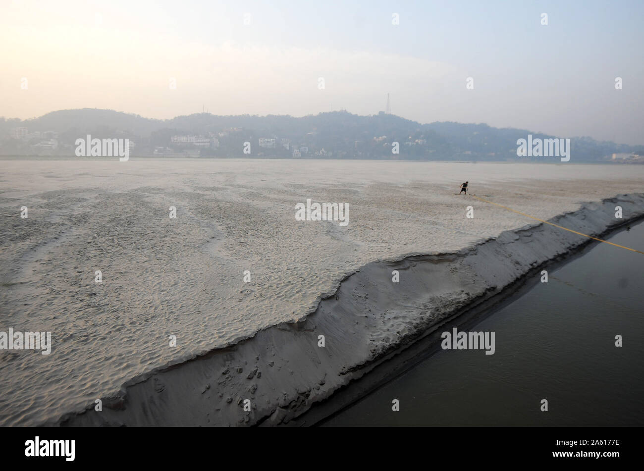 Pre-dawn cast off, man releasing ropes from a mooring in the fine sand ...