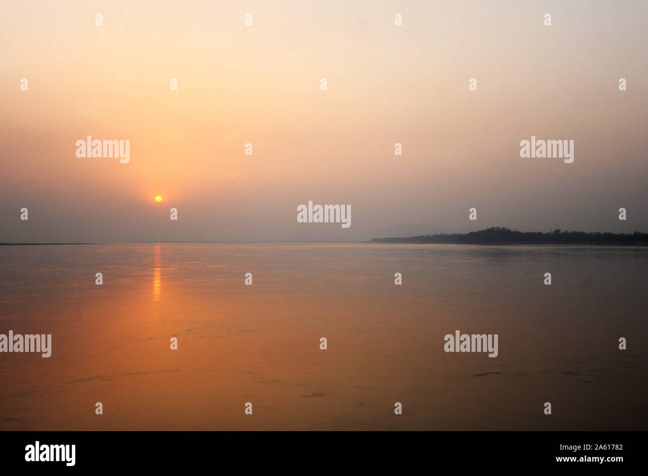 Sun setting over the vast waters of the mighty Brahmaputra River, Assam ...