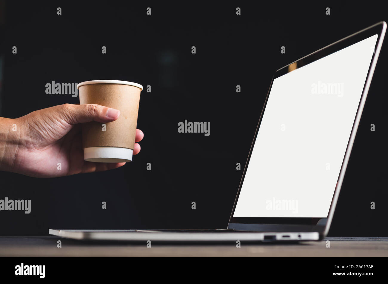 human hand in front of laptop on the table with blank, mockup image of ...