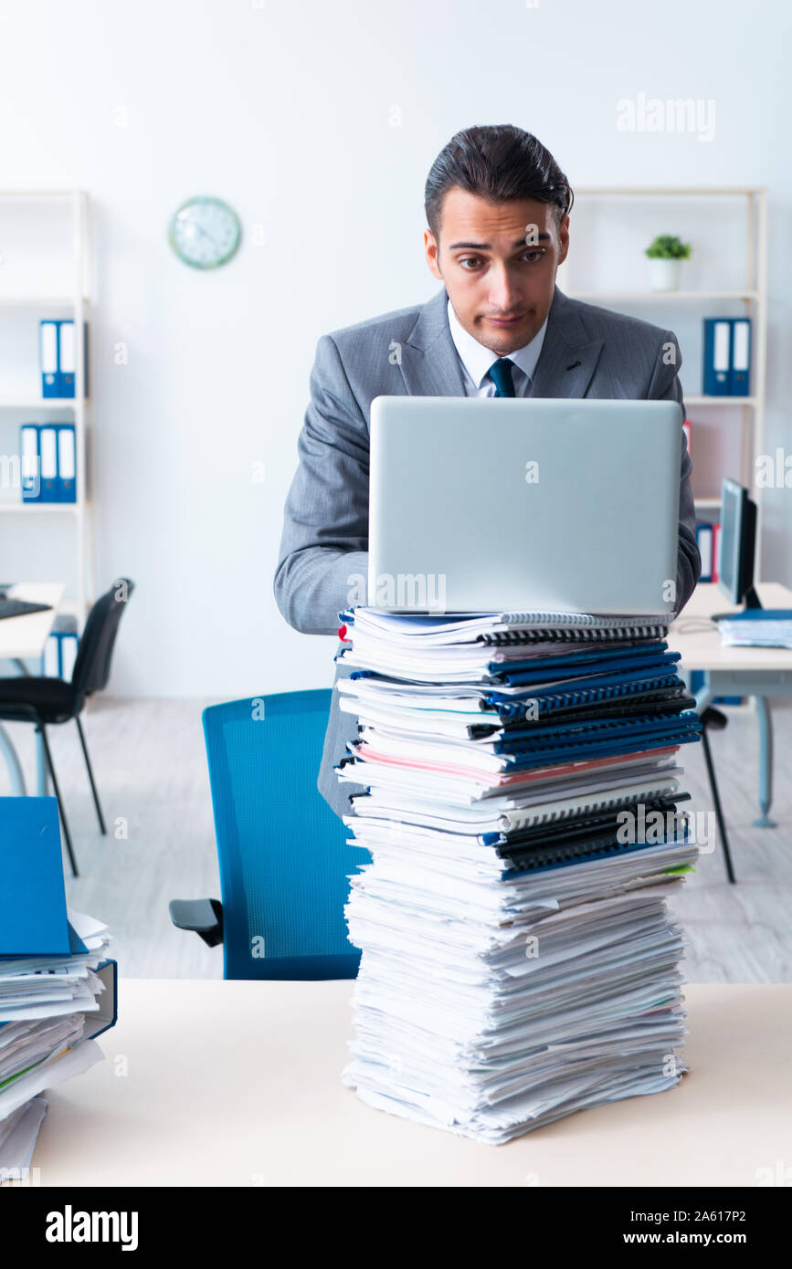 The businessman with heavy paperwork workload Stock Photo - Alamy