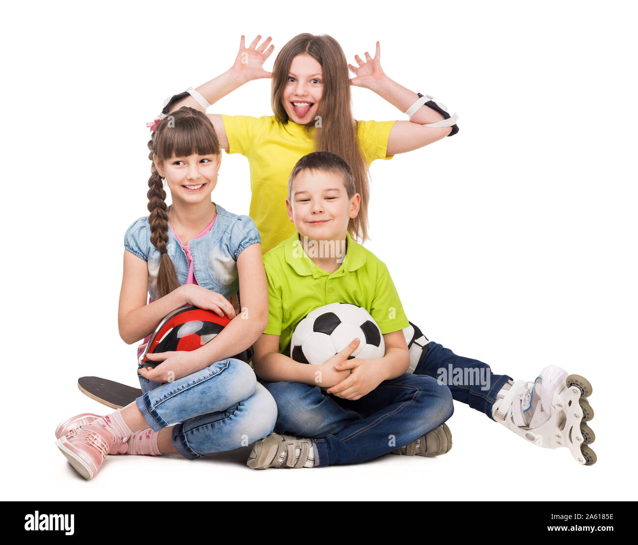 playful little boy and girls sitting on the floor with ball, skate and ...