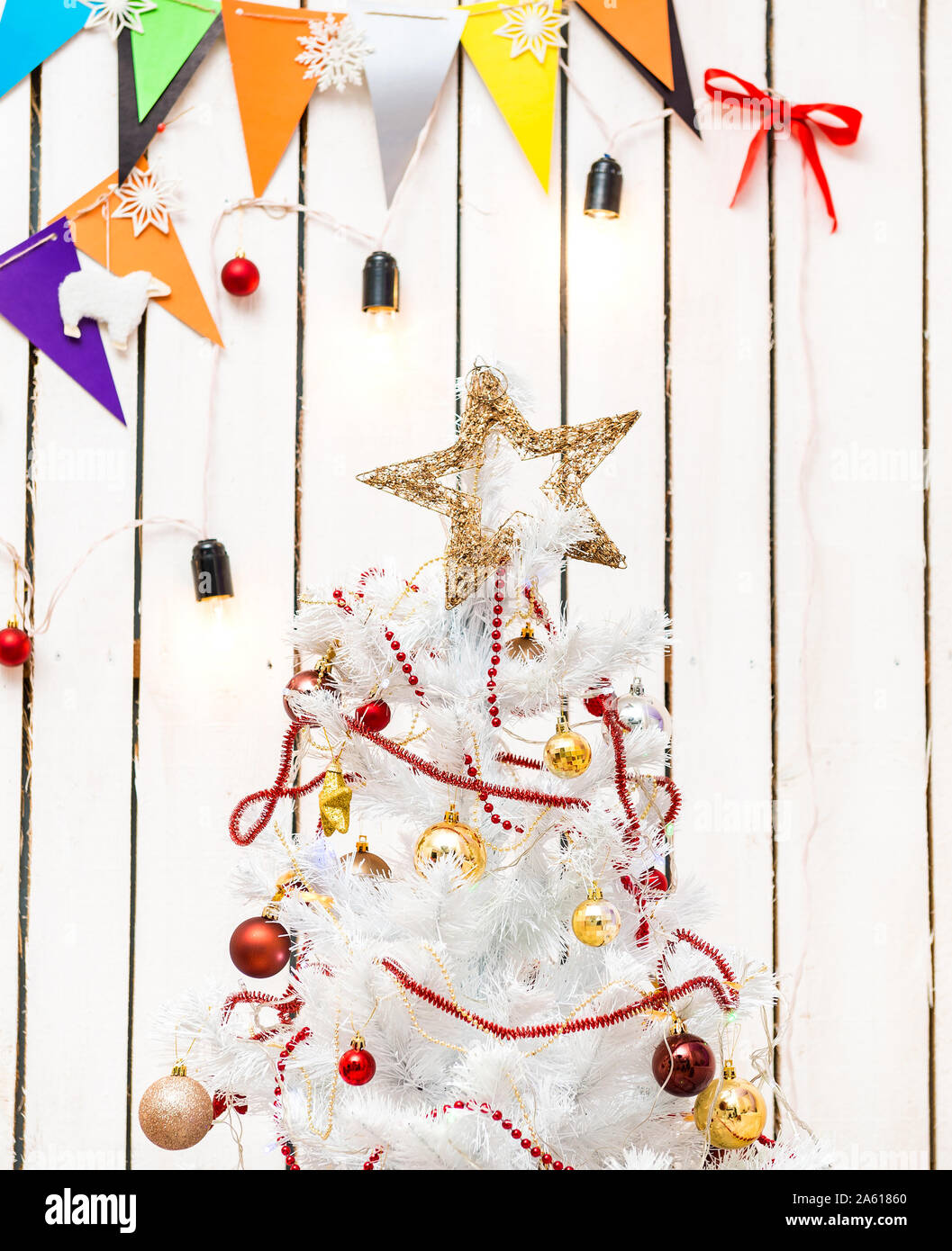 golden toy star on top of white christmas tree in decorated room Stock ...