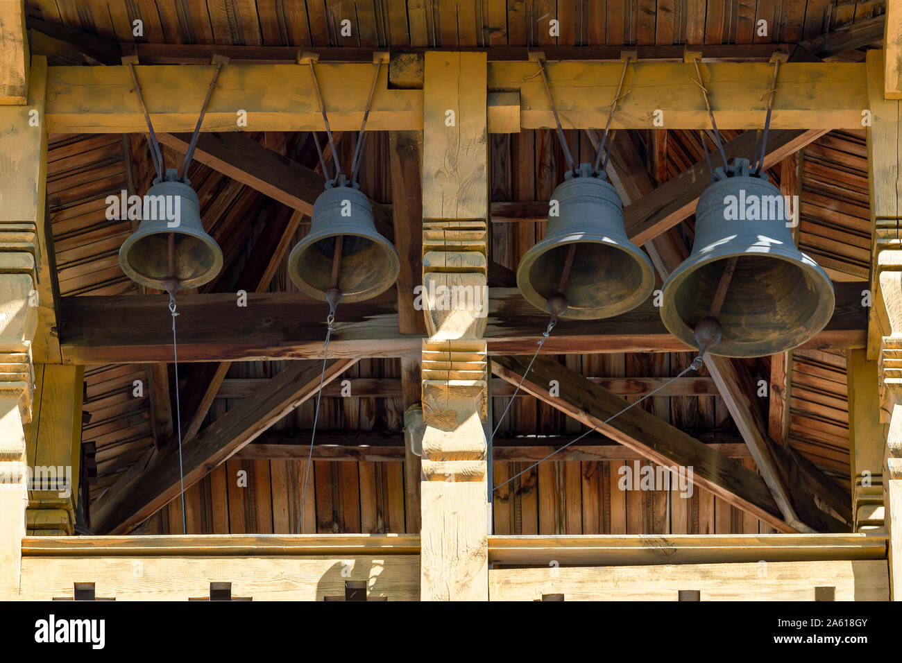 Bells and bell tower in an old wooden christian temple. Front view ...