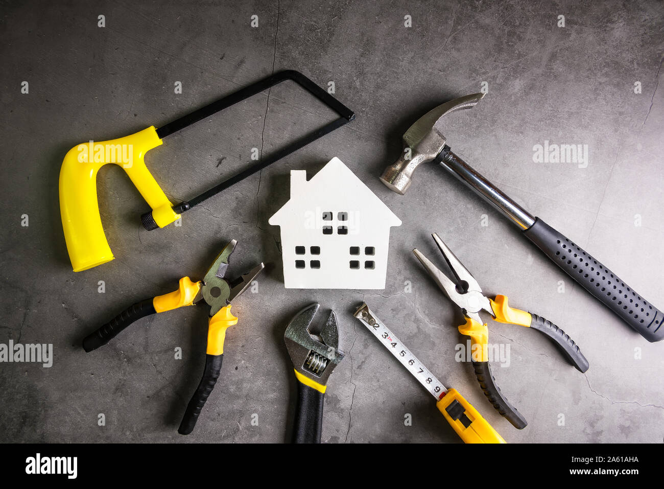 Wooden house and construction tools on stone pattern background with ...