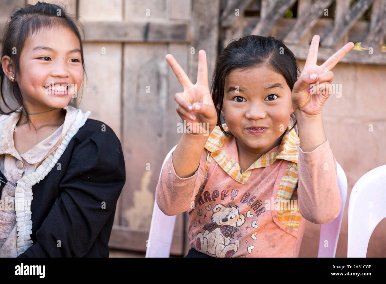 Children in a Khmu village in Laos gather around a table, enjoying a ...