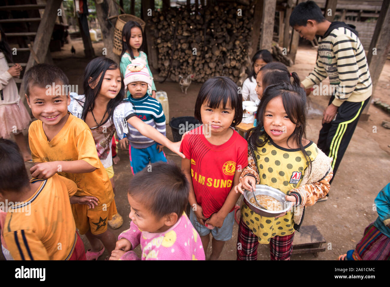 Children in a Khmu village in Laos gather around a table, enjoying a ...