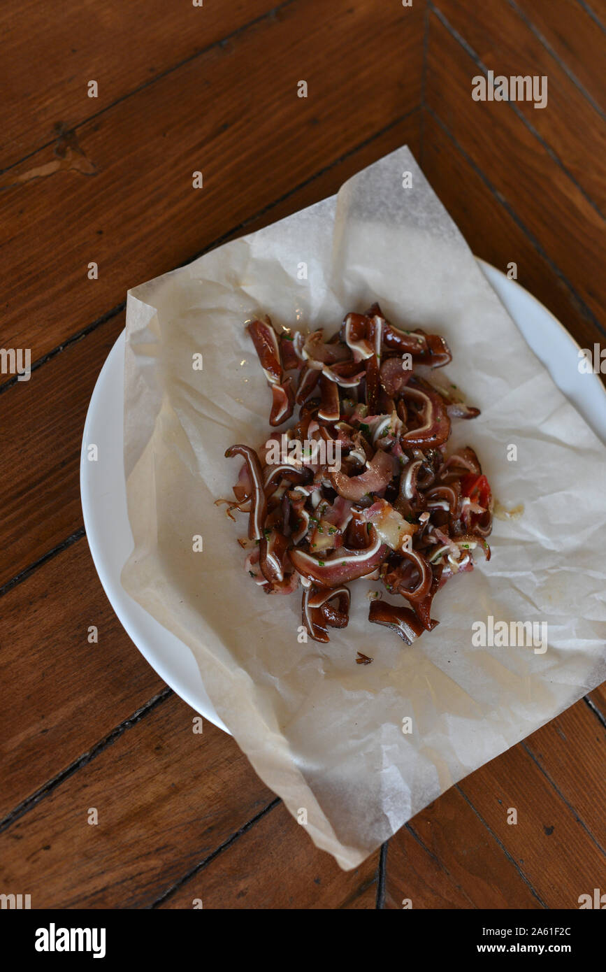 Pig ears as a beer dish in the beer bar. Tasty fried pig ears with ...