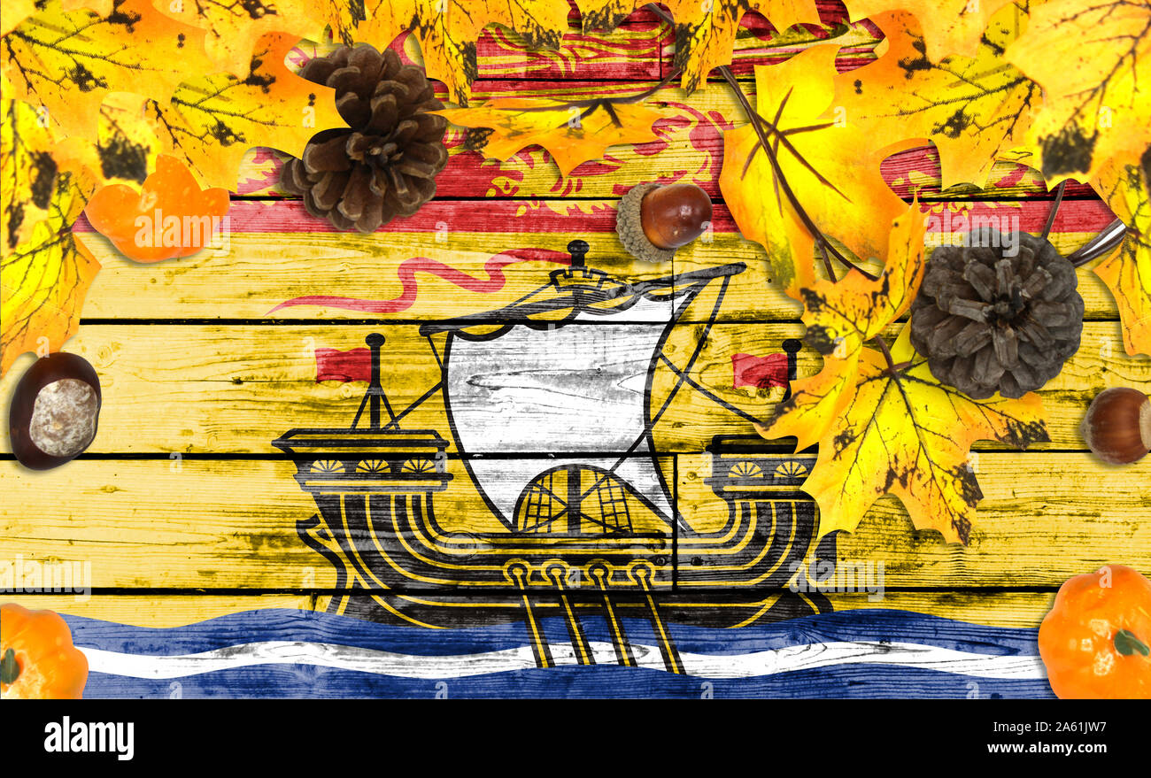 New Brunswick flag on autumn wooden background with leaves and good ...