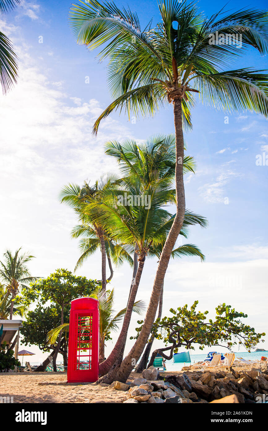 Red phone booth in Dickenson's bay Antigua. Beautiful landscape with a ...