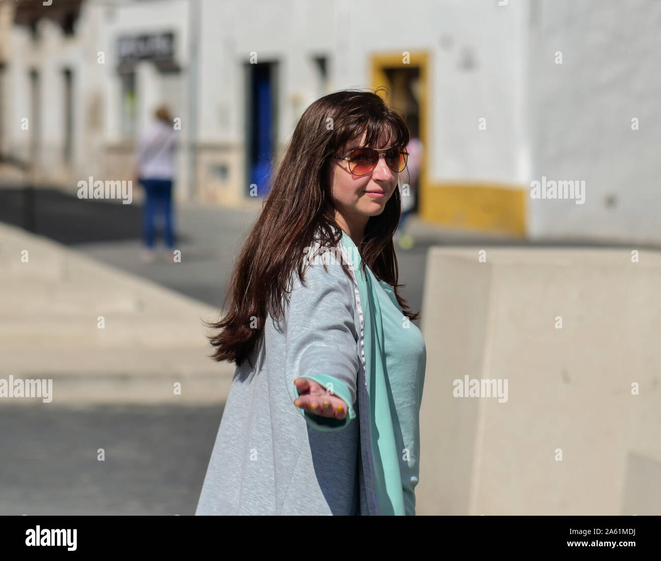 A brunette young woman in glasses, a plus size model, is walking down ...