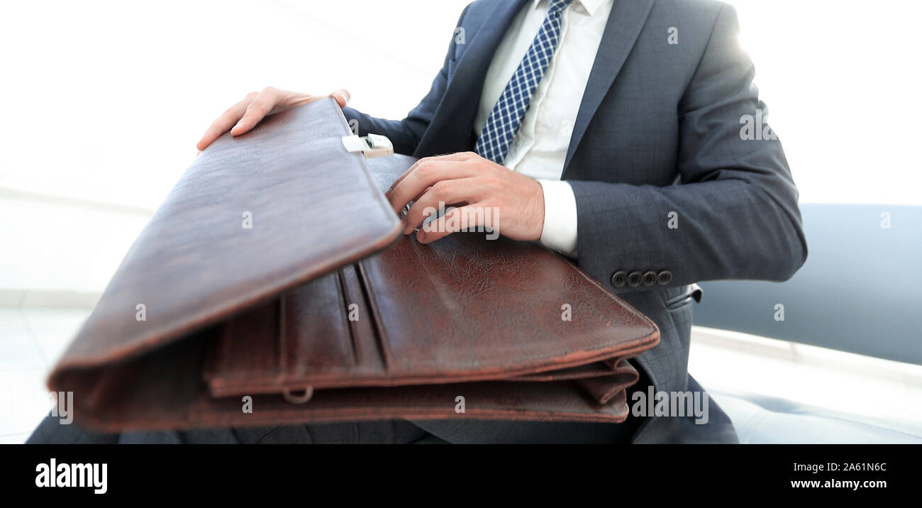 businessman's hand with suitecase in a modern office Stock Photo - Alamy