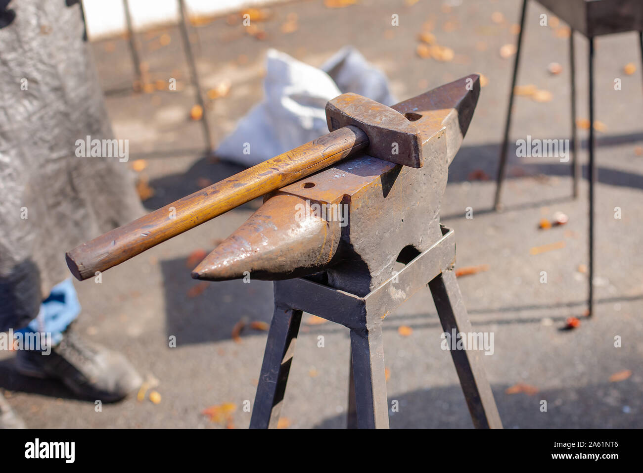 A blacksmith forges a metal blank on the anvil at a fair in the ...