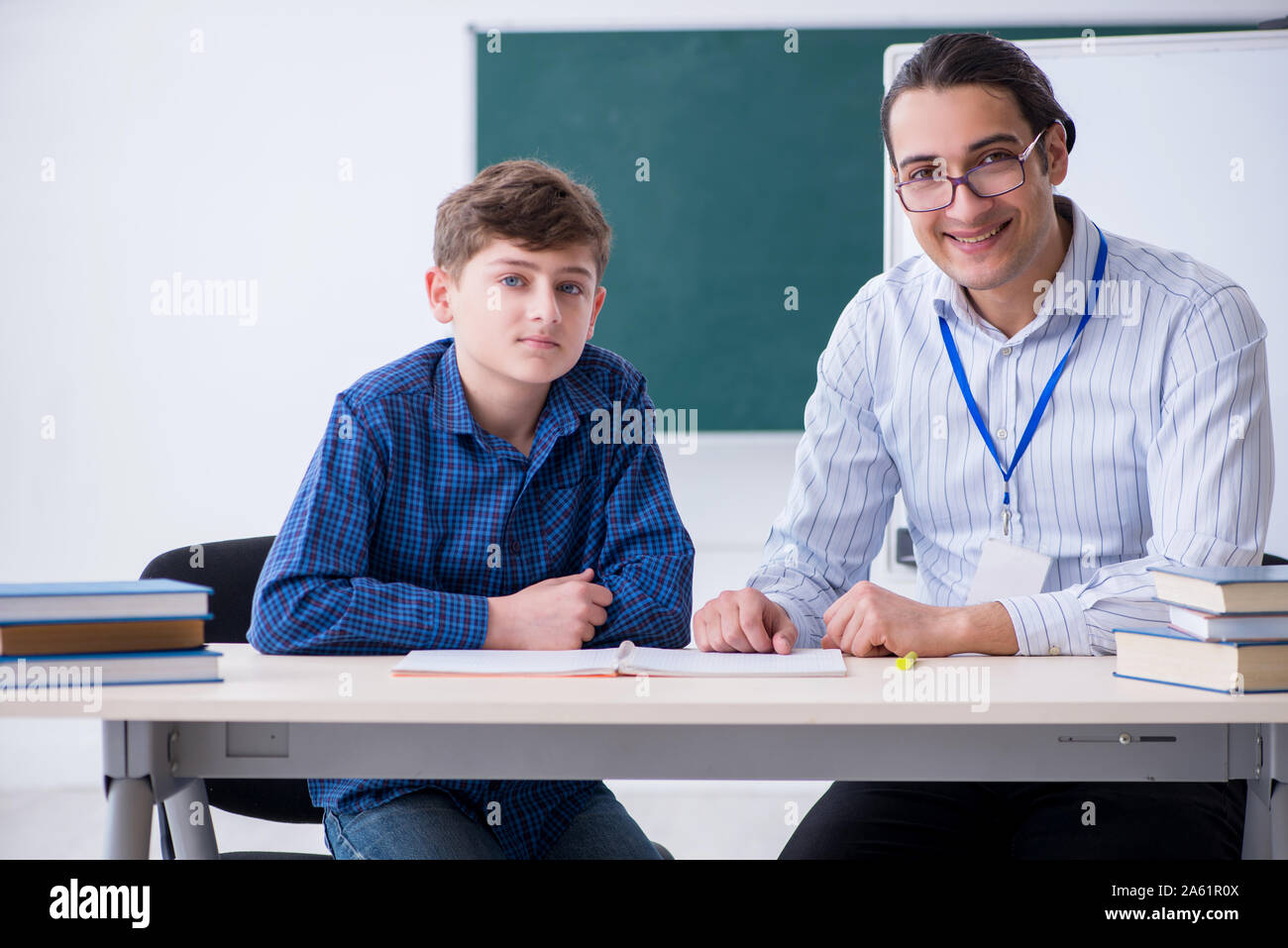 The young male teacher and boy in the classroom Stock Photo - Alamy